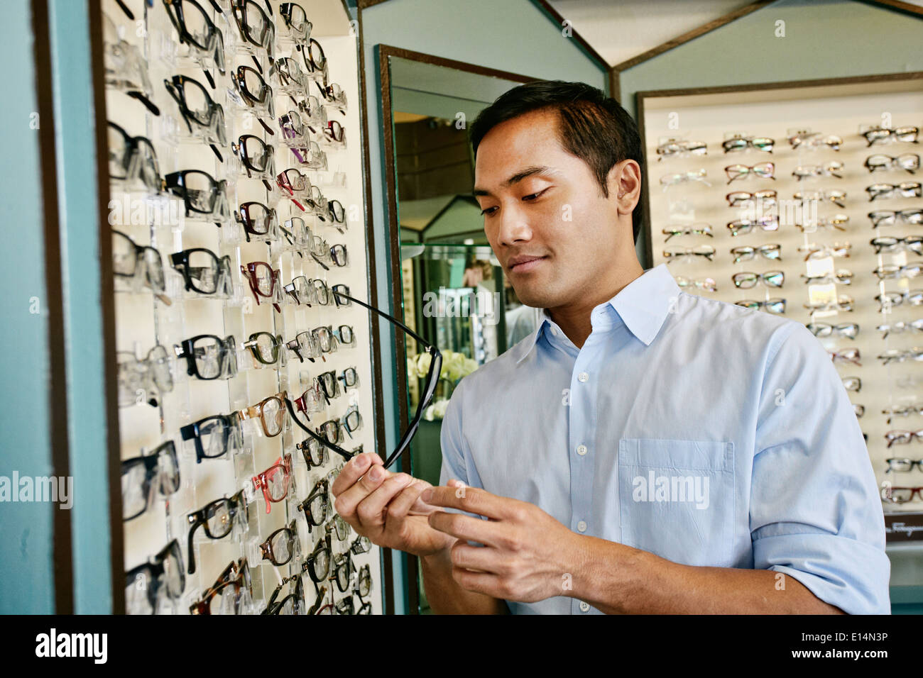 Filipino man trying on glasses at optometrist Stock Photo - Alamy