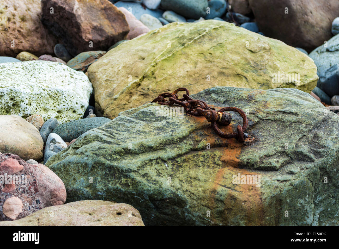 A rusty chain secured to a rock Stock Photo - Alamy