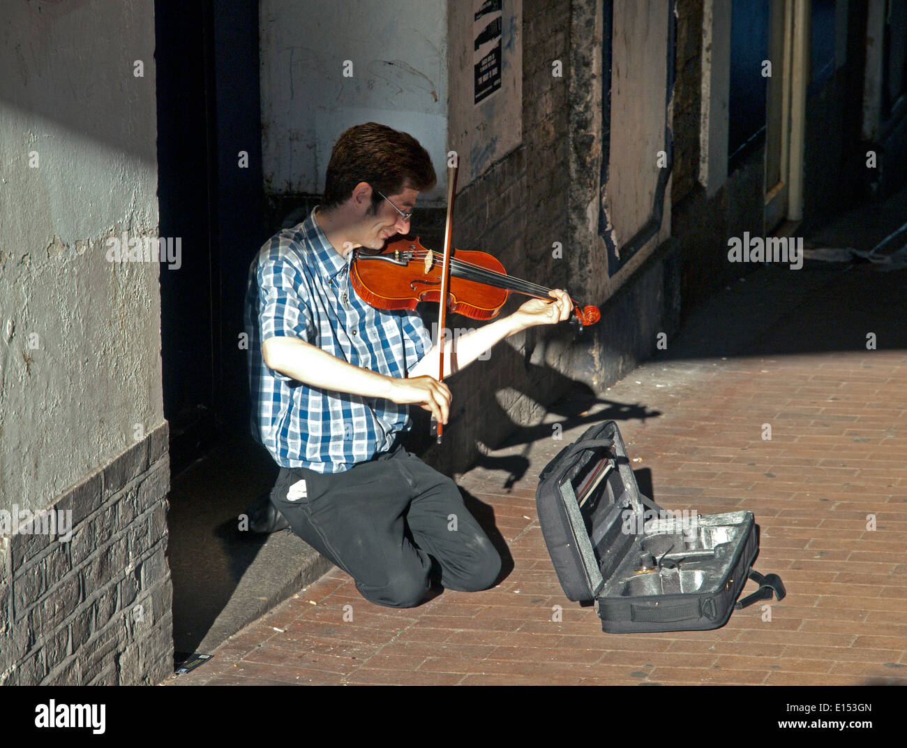 A busker plays his violin on a street in Brighton Stock Photo - Alamy