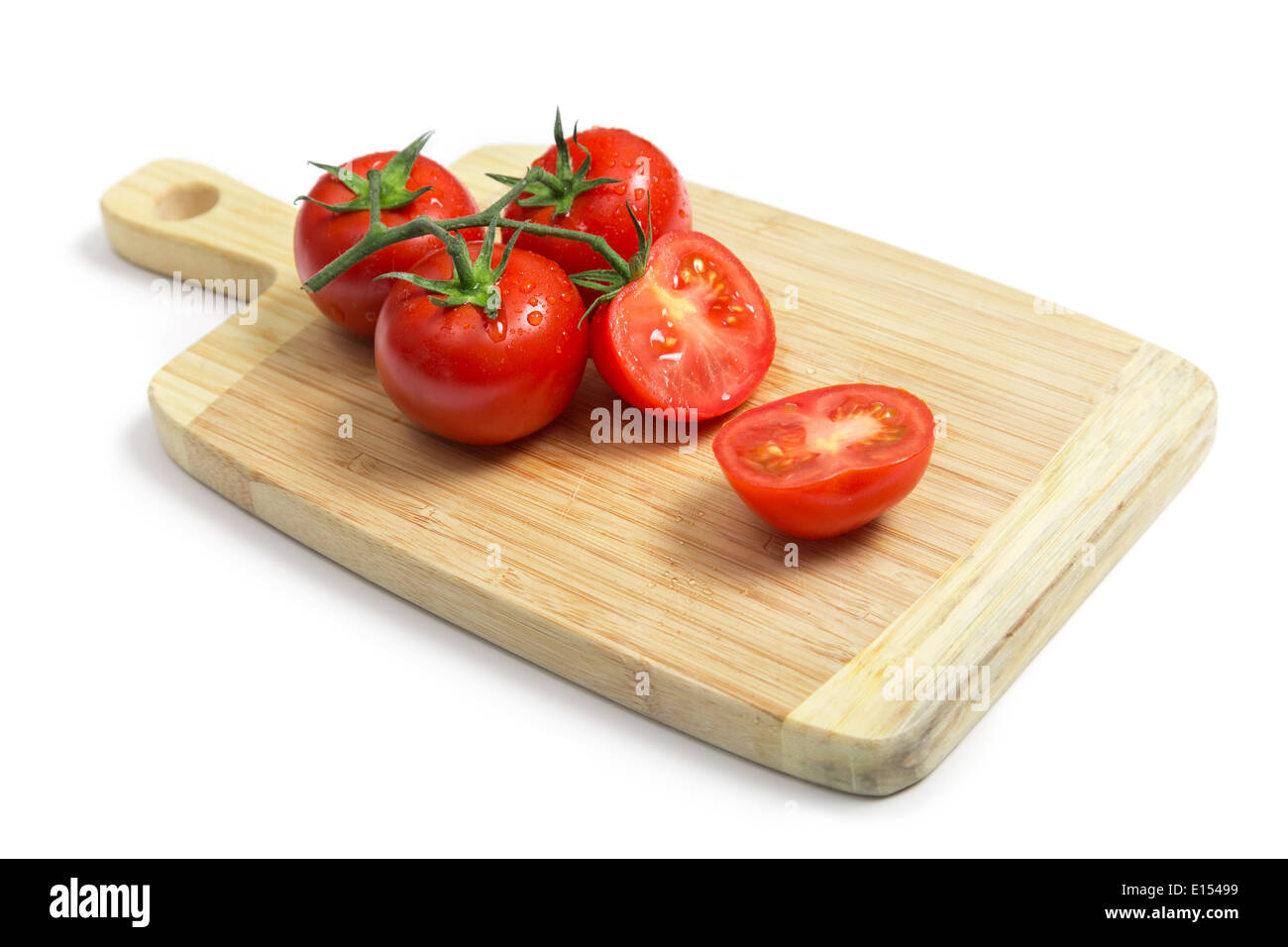 Fresh tomatoes on wooden chopping board, isolated on white background ...