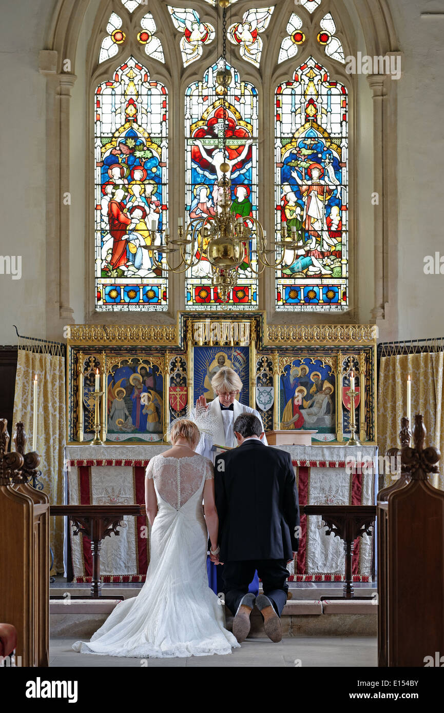 A newly married couple receiving a blessing at the altar in a Stock ...
