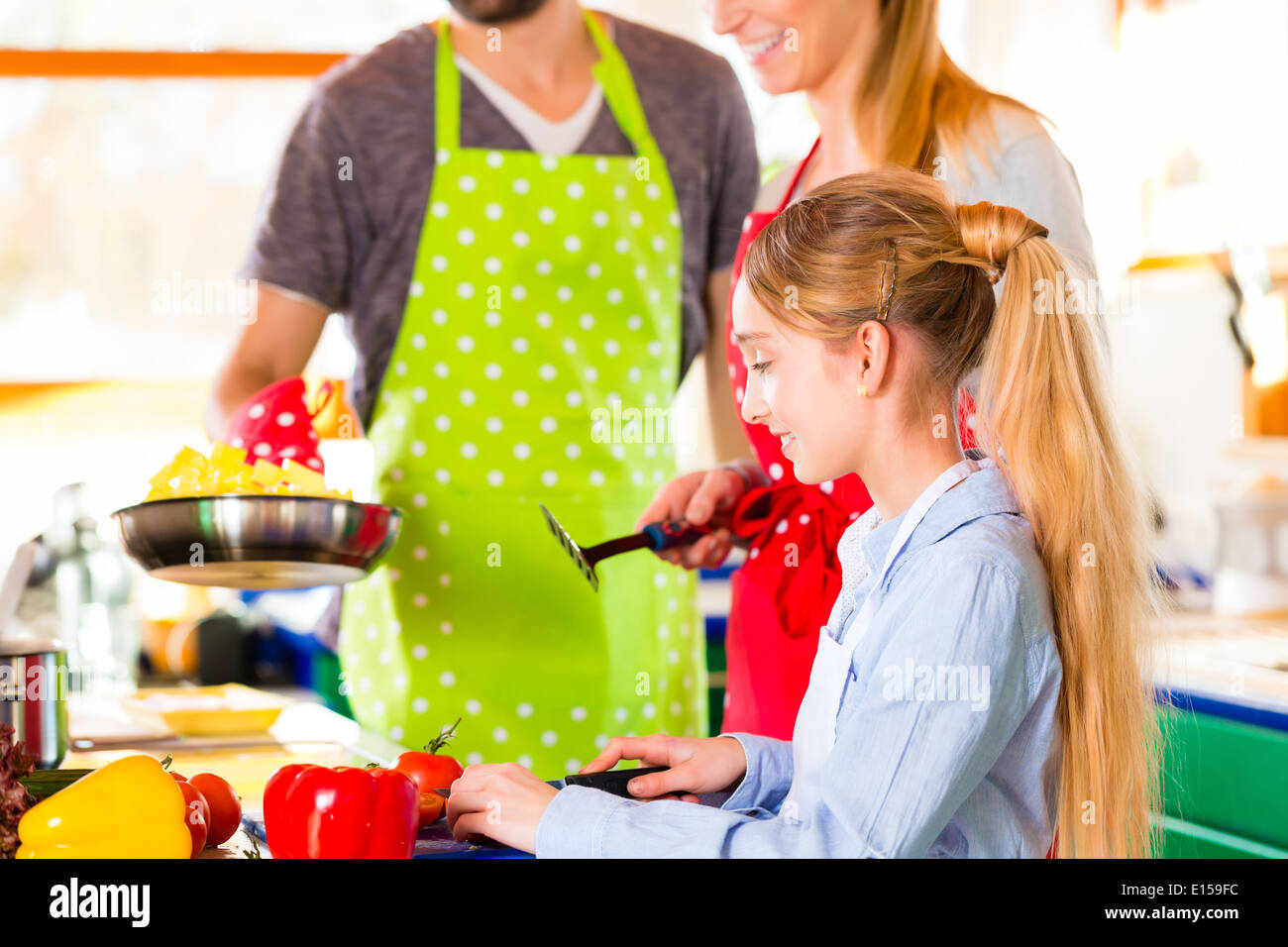 Family - Parents and child -preparing healthy meal in domestic kitchen ...