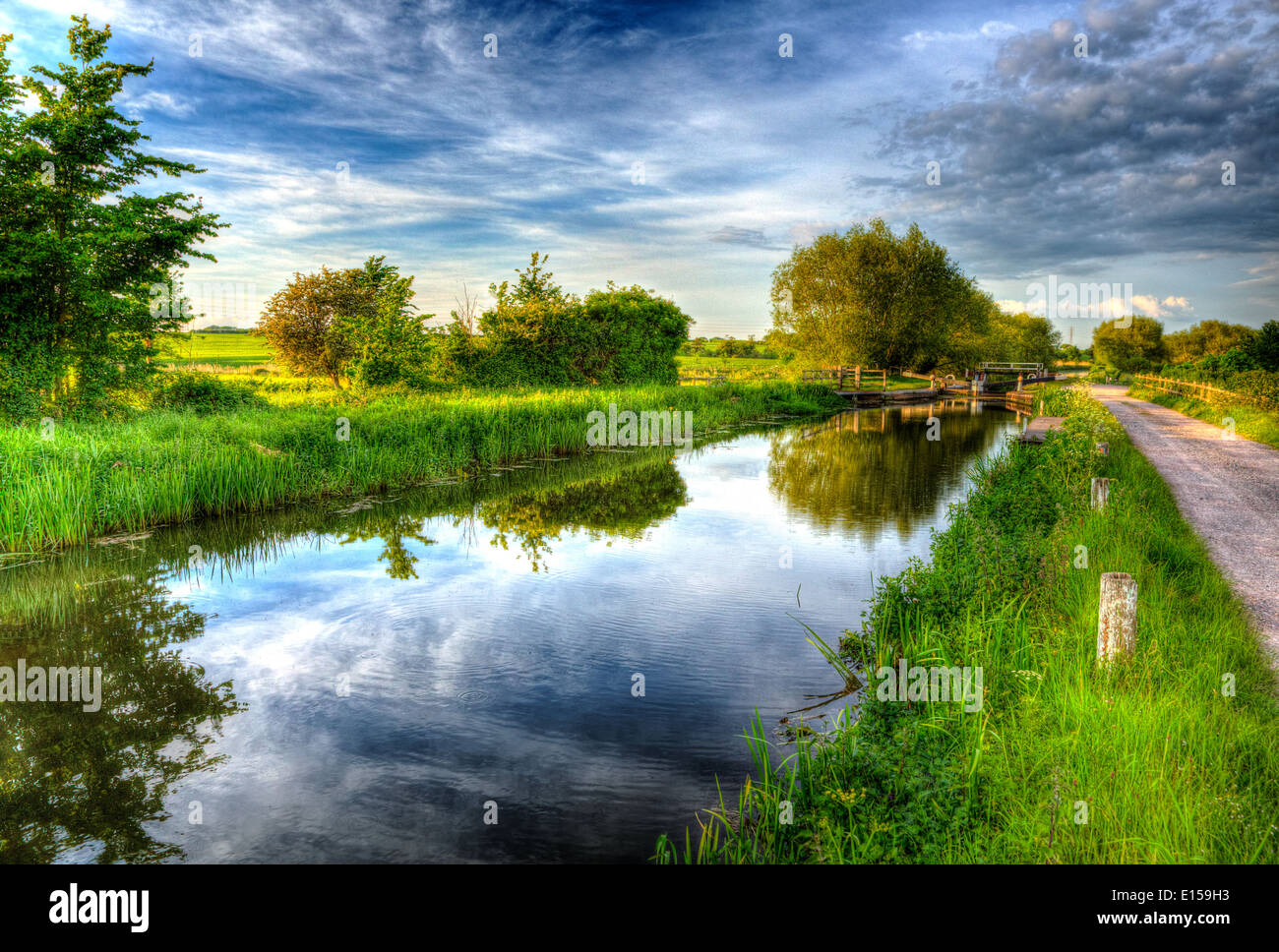English countryside scene with canal and lock gates in colourful bright ...