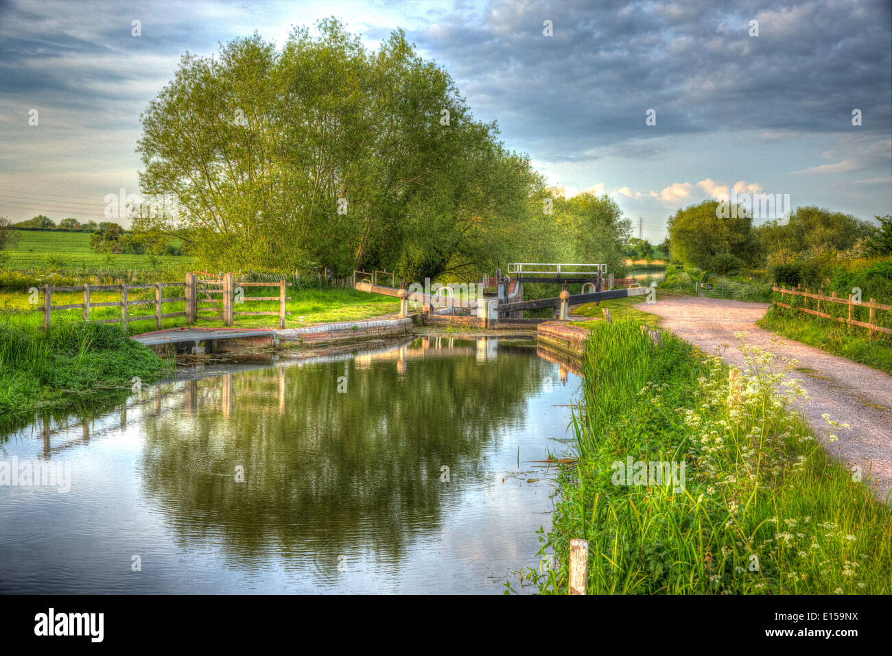 English countryside scene with canal and lock gates in colourful bright ...