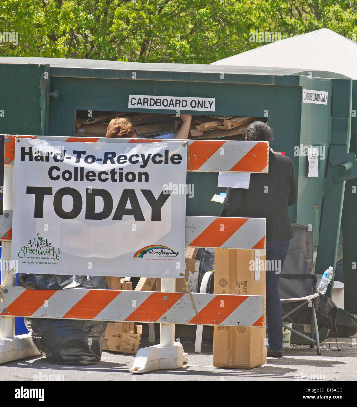 People stuff a dumpster with hard to recycle cardboard items Stock ...
