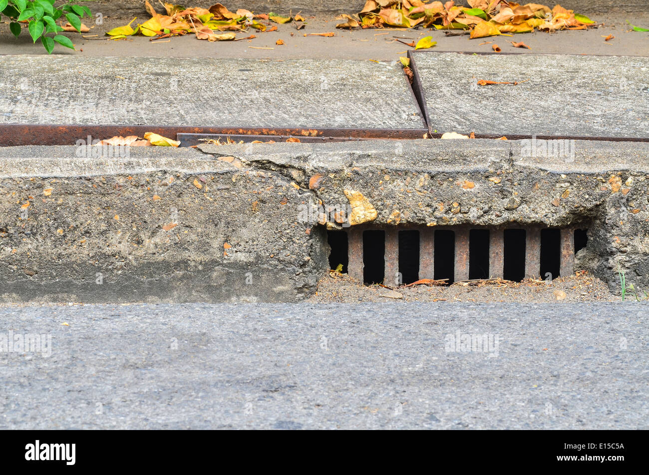 Sidewalk with a street drainage Stock Photo - Alamy