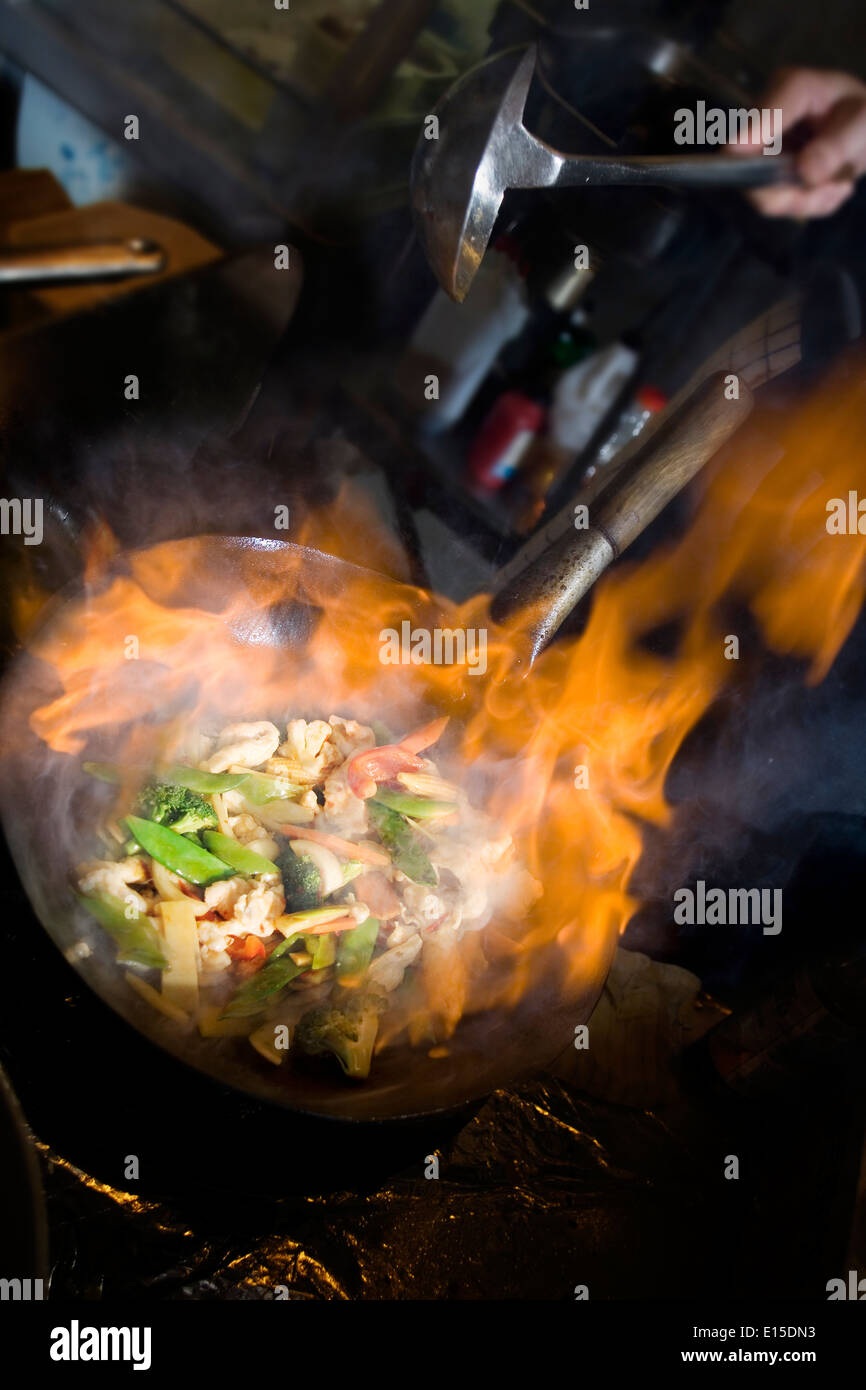 Cooking with wok in flames Stock Photo: 69576671 - Alamy