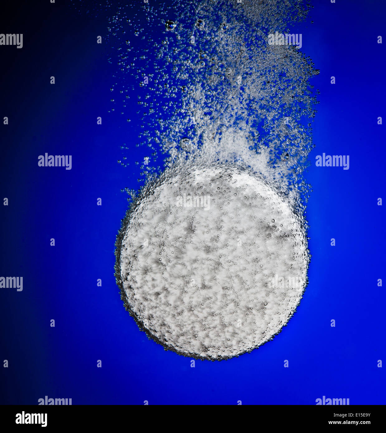 Effervescent tablet in water with bubbles on a blue background Stock ...