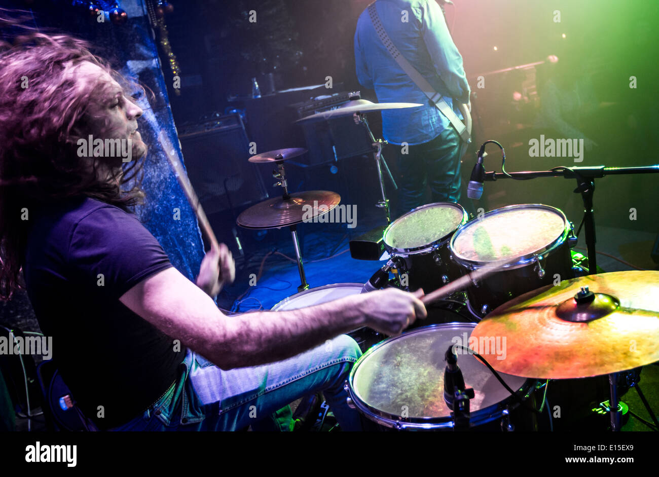 Drummer (blurred motion) playing on drum set on stage. Focus on the ...