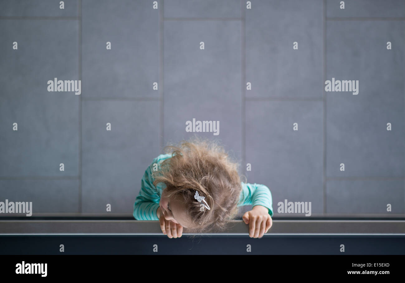 Little girl looking over railing, view from above Stock Photo - Alamy