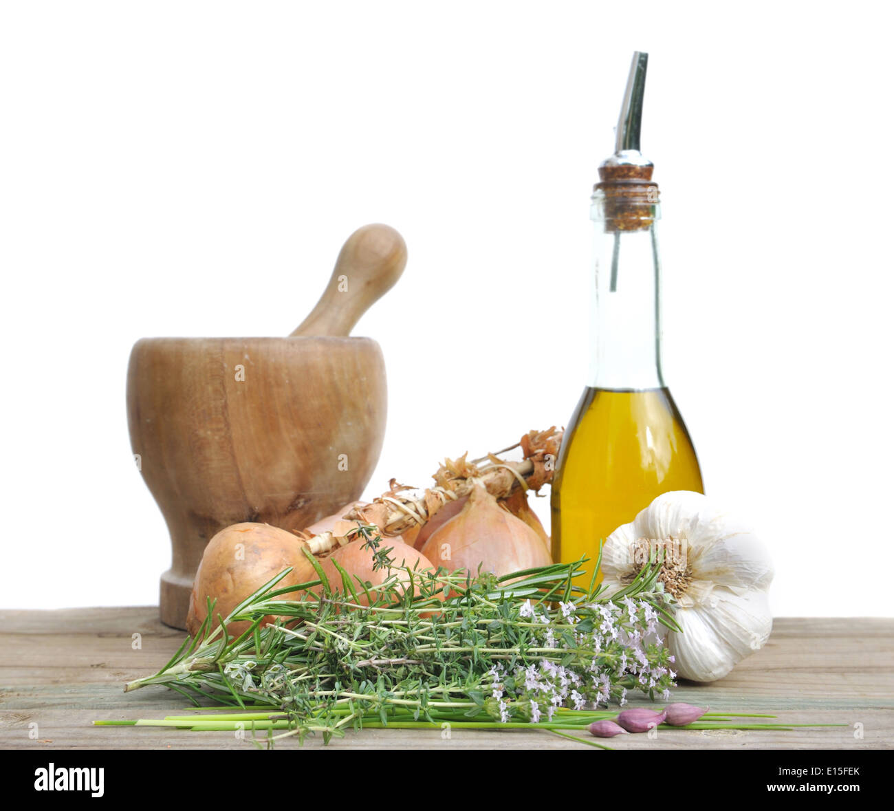 herbal, onions, garlic, oil and pestle on a plank on white background ...