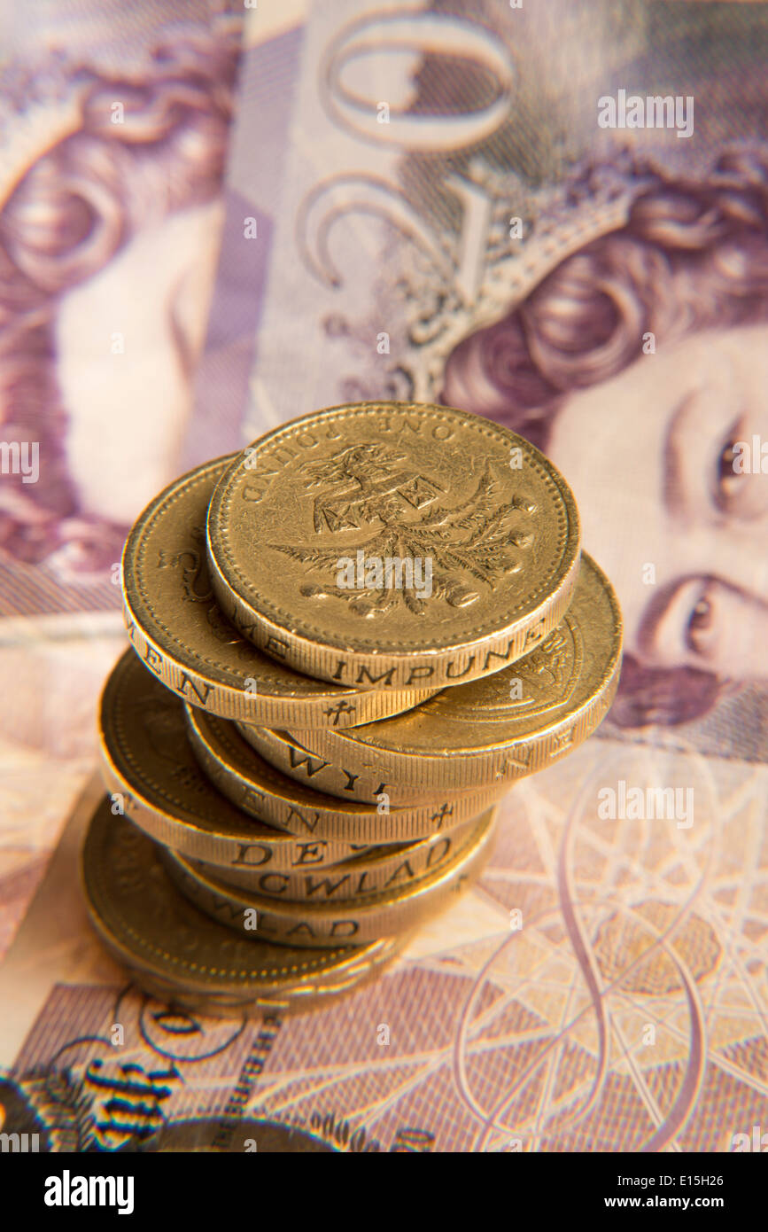 a pile of pound coins and some twenty pound notes Stock Photo - Alamy