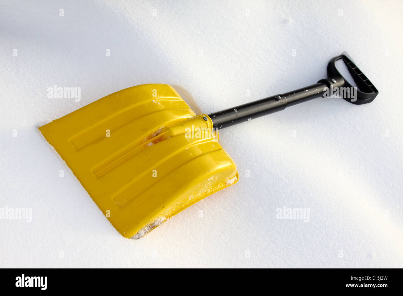 Yellow snow shovel lying on the snow Stock Photo - Alamy