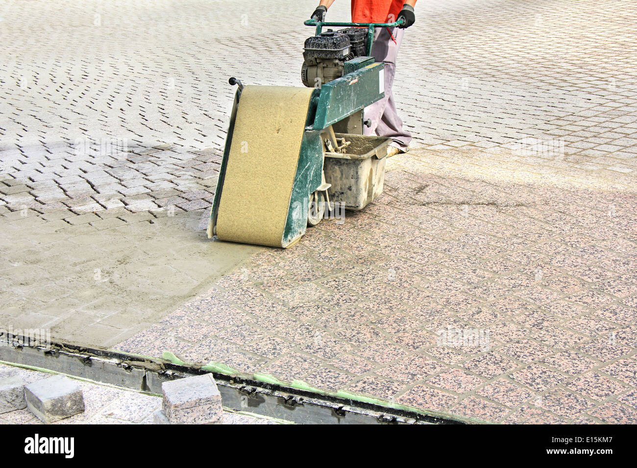 Worker with machine, grouting compound street paved with bricks Stock ...