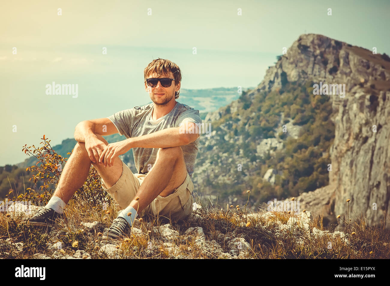 Young Man relaxing outdoor with mountains on background Summer ...
