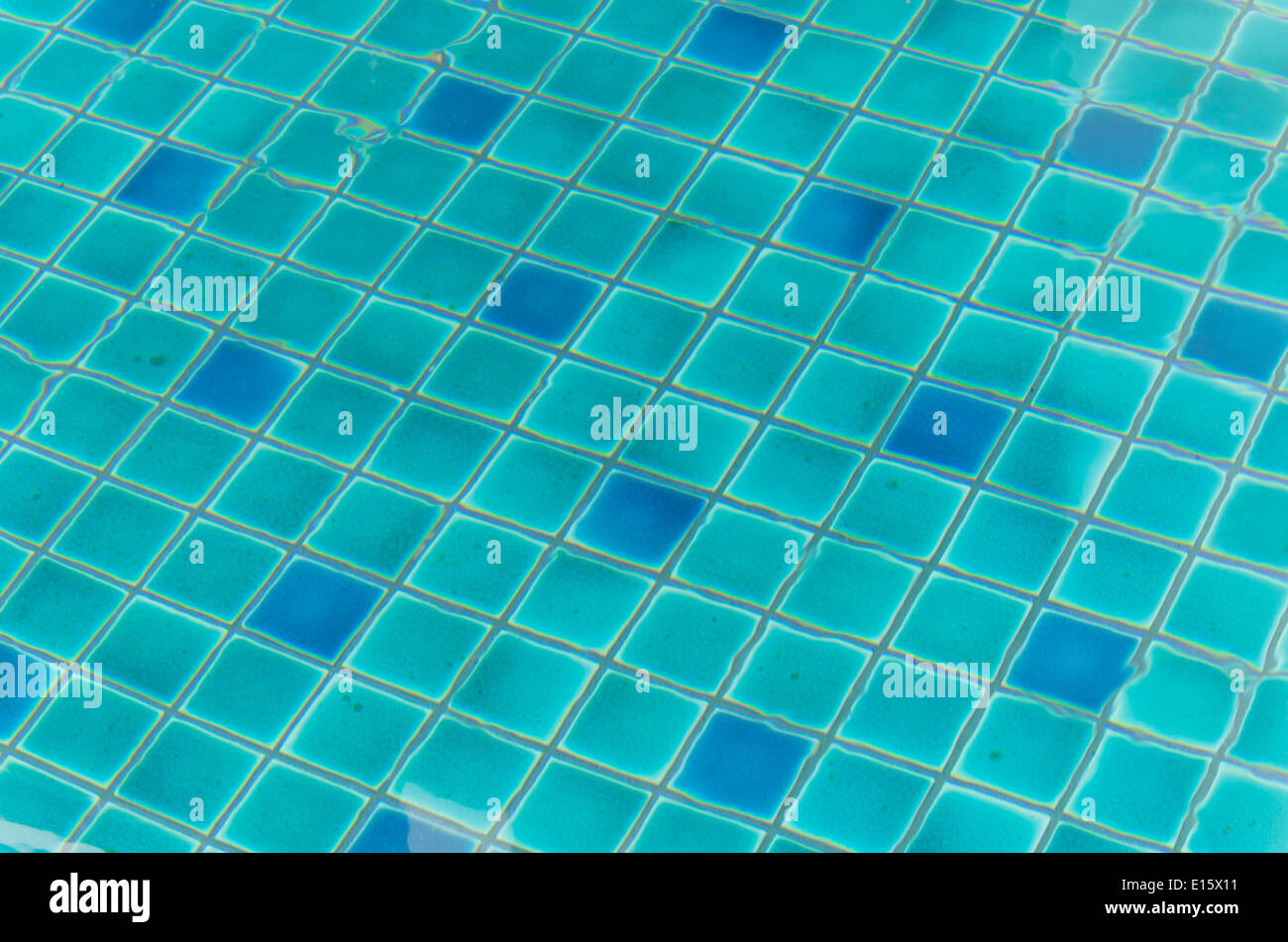 reflection on the blue clear water ripples of swimming pool with mosaic ...