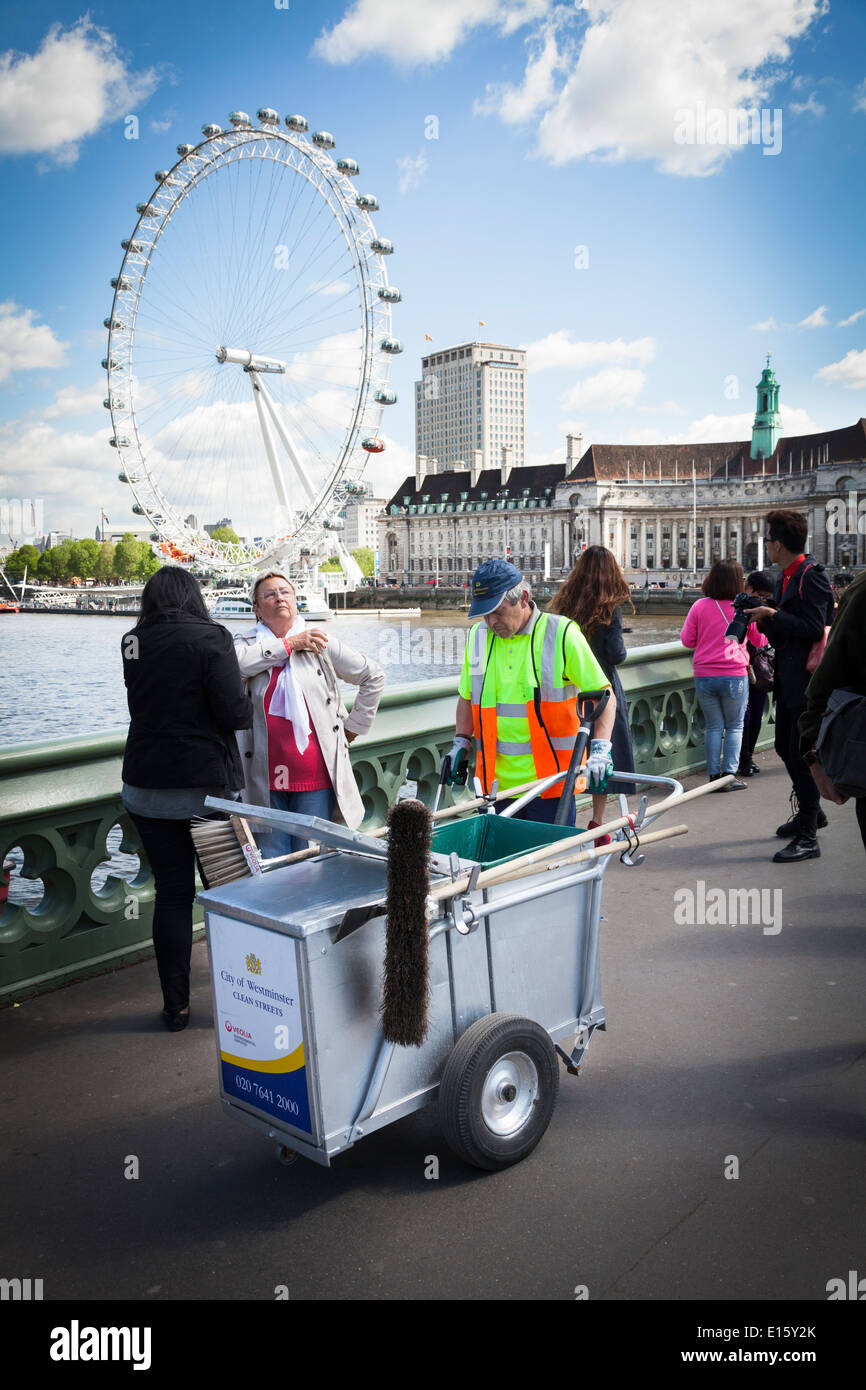 Street cleaner with cart amongst tourists with London Eye Stock Photo ...