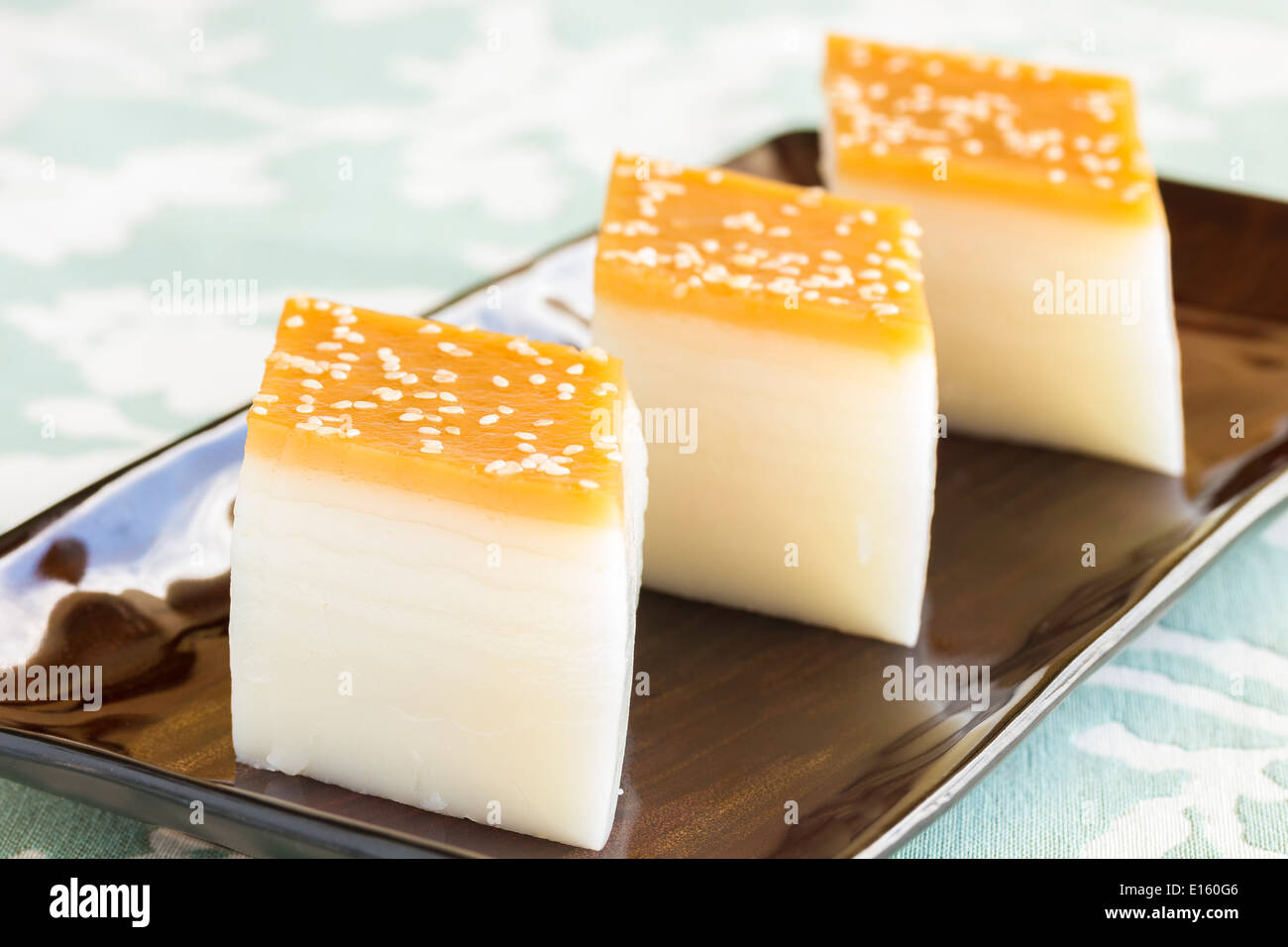Layered Chinese rice cakes with sesame seed topping Stock Photo - Alamy