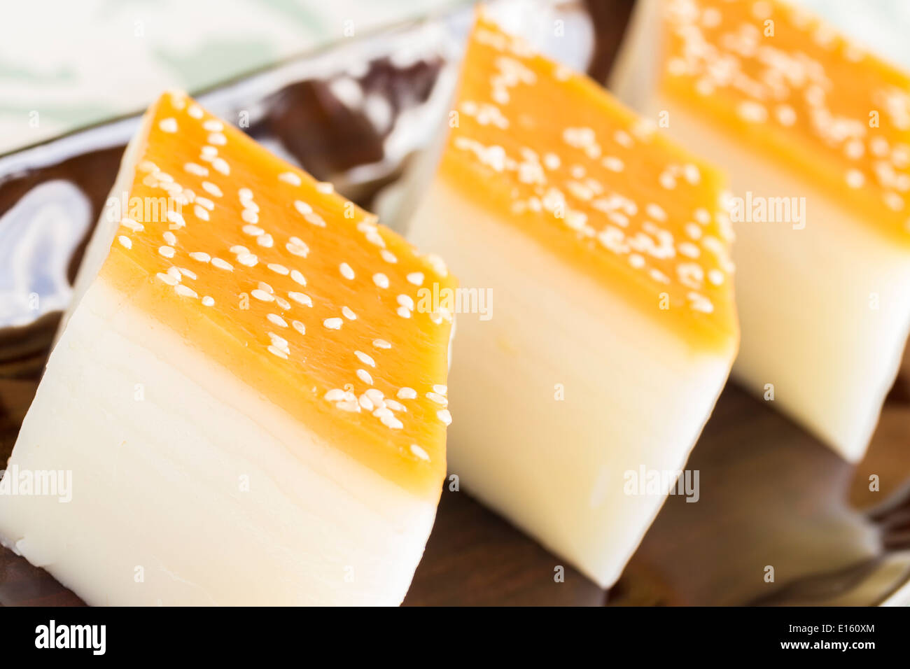 Layered Chinese rice cakes with sesame seed topping Stock Photo - Alamy