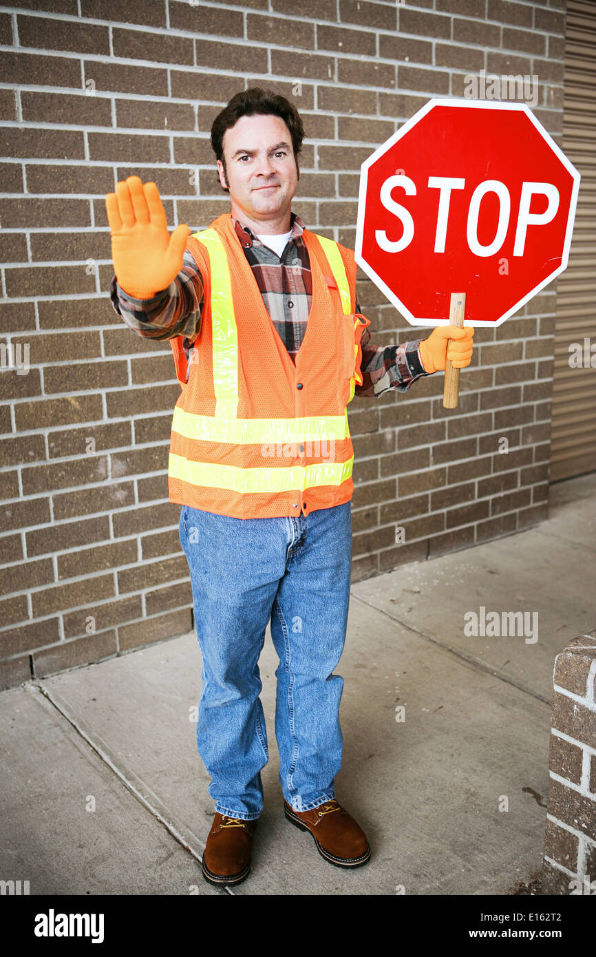 Handsome school crossing guard holding a stop sign Stock Photo - Alamy