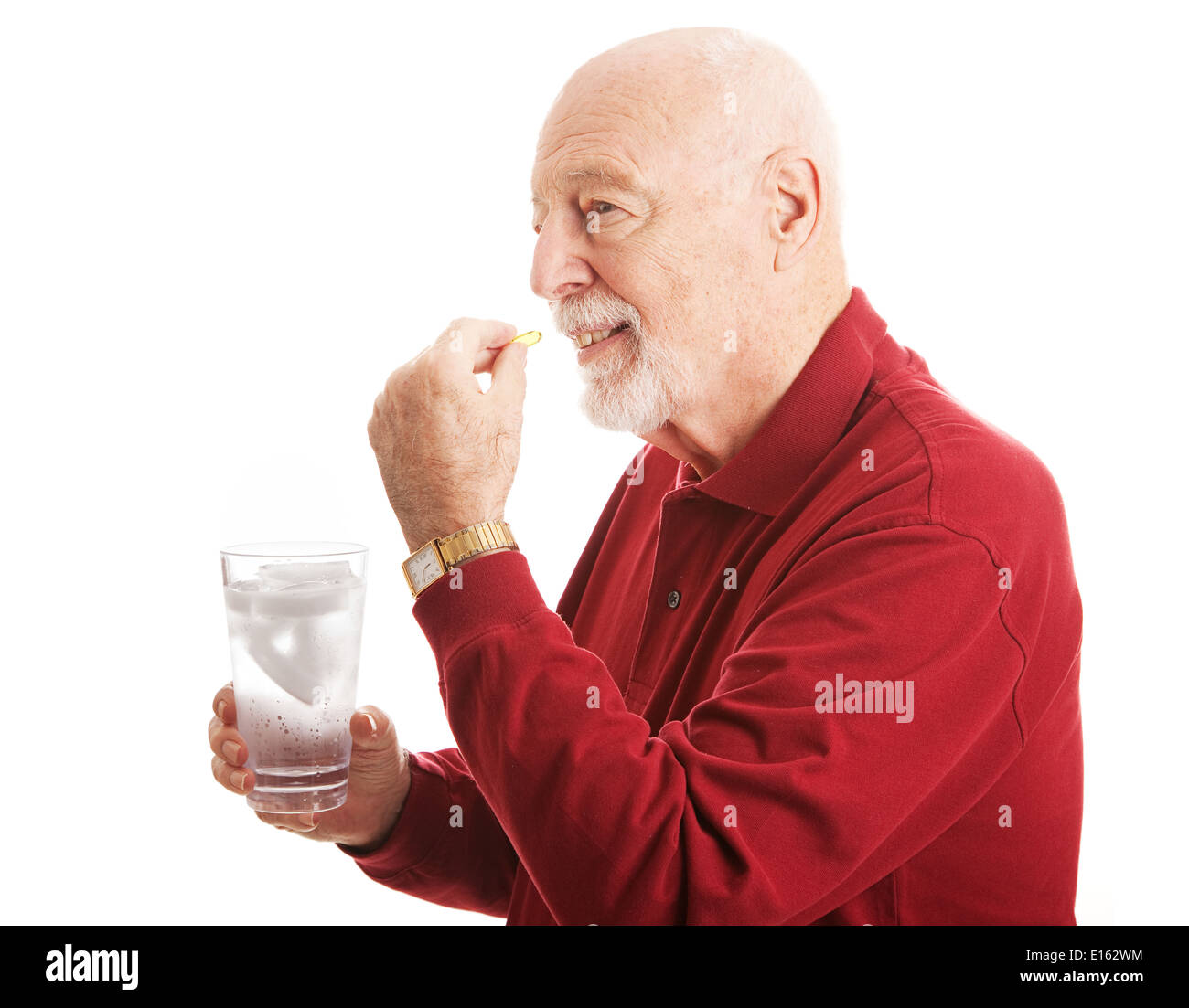Handsome senior man stays healthy by taking a fish oil supplement with ...