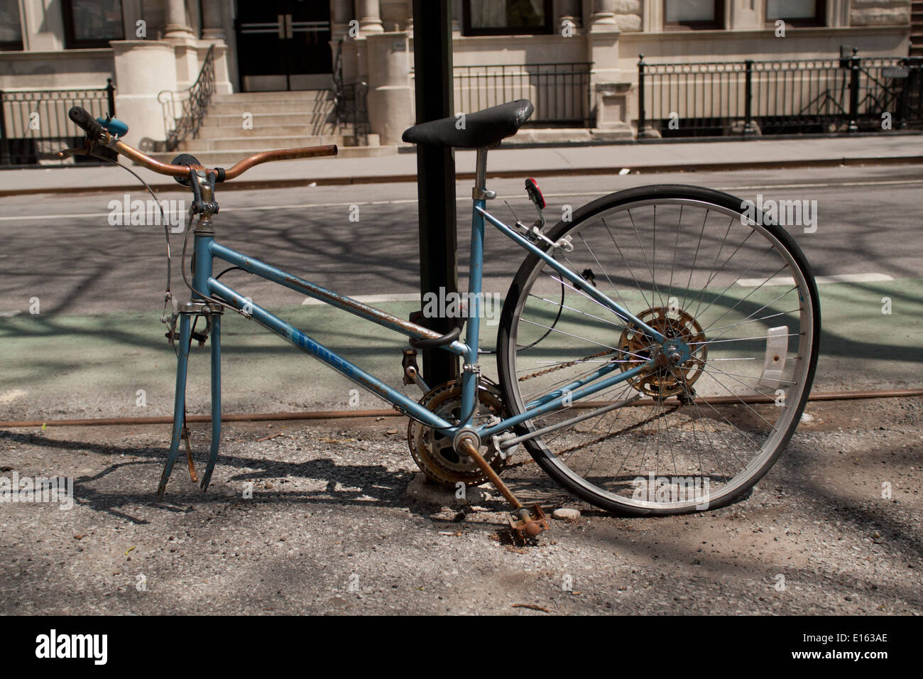 Old rusty bicycle with missing lost or stolen front wheel, attached to ...