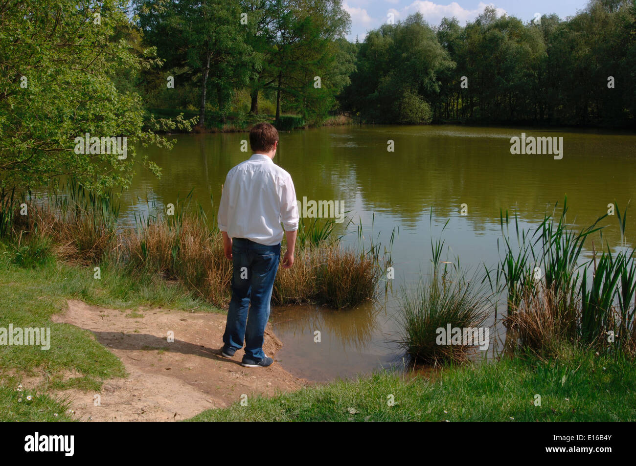 A Teenage Man,Standing At The Edge Of A Freshwater Lake Stock Photo - Alamy