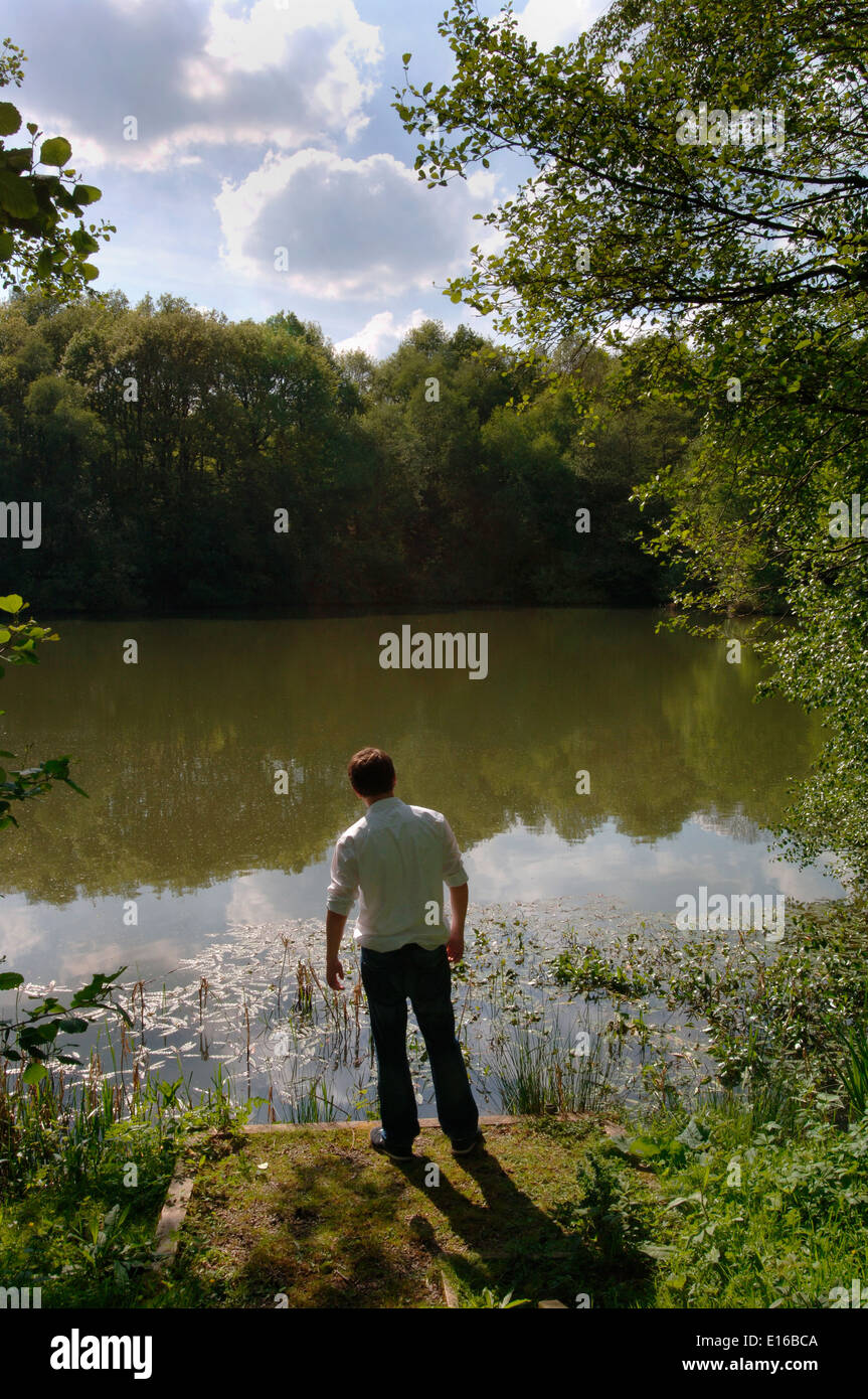 A Teenage Man,Standing At The Edge Of A Freshwater Lake Stock Photo - Alamy