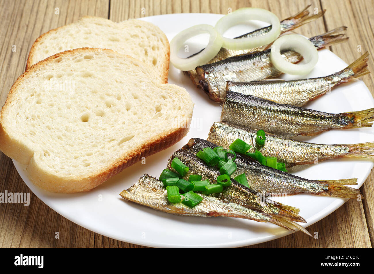 Smoked sprats and bread on a white plate Stock Photo - Alamy
