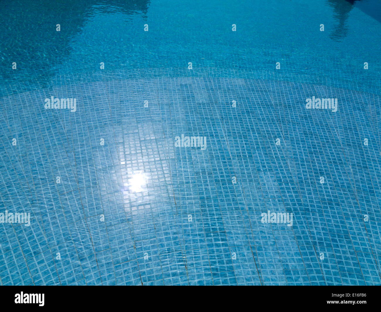 Close up details of sun reflected on the surface of a swimming pool ...
