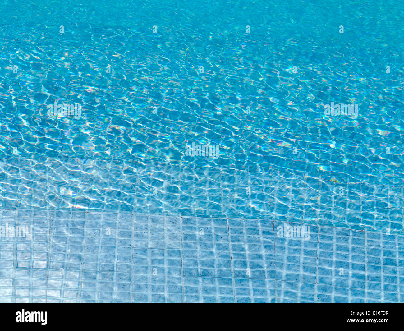 Close up details of swimming pool steps seen through the blue water ...