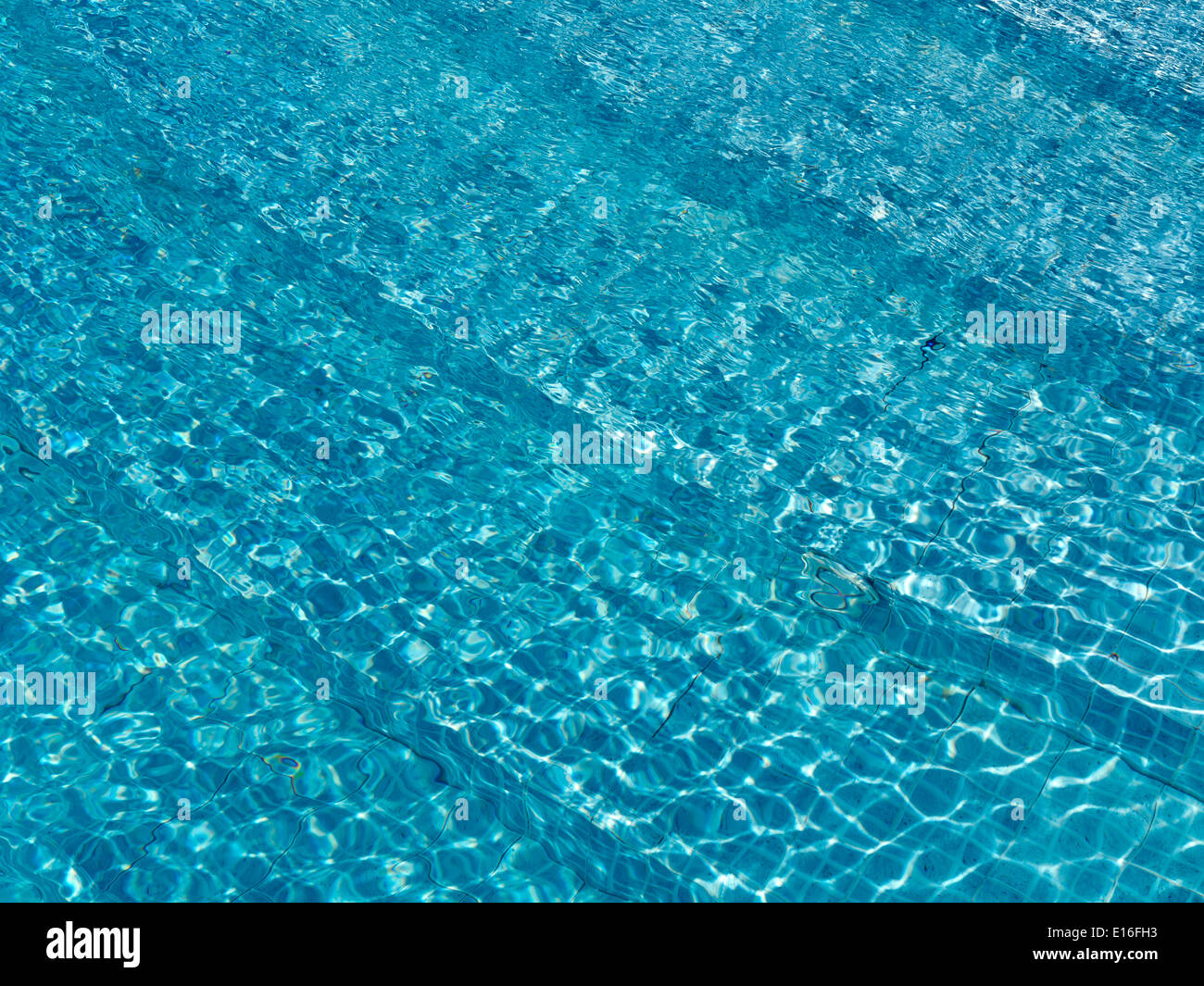 Close up details of swimming pool steps seen through the blue water ...
