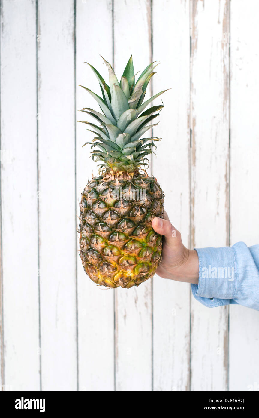 Hand holding pineapple Stock Photo - Alamy