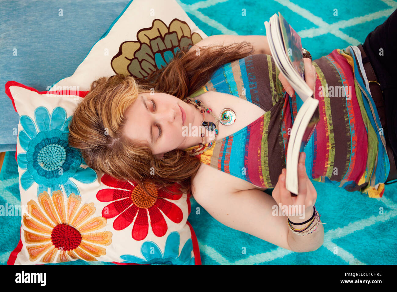 Teenage girl lying on back reading book Stock Photo - Alamy