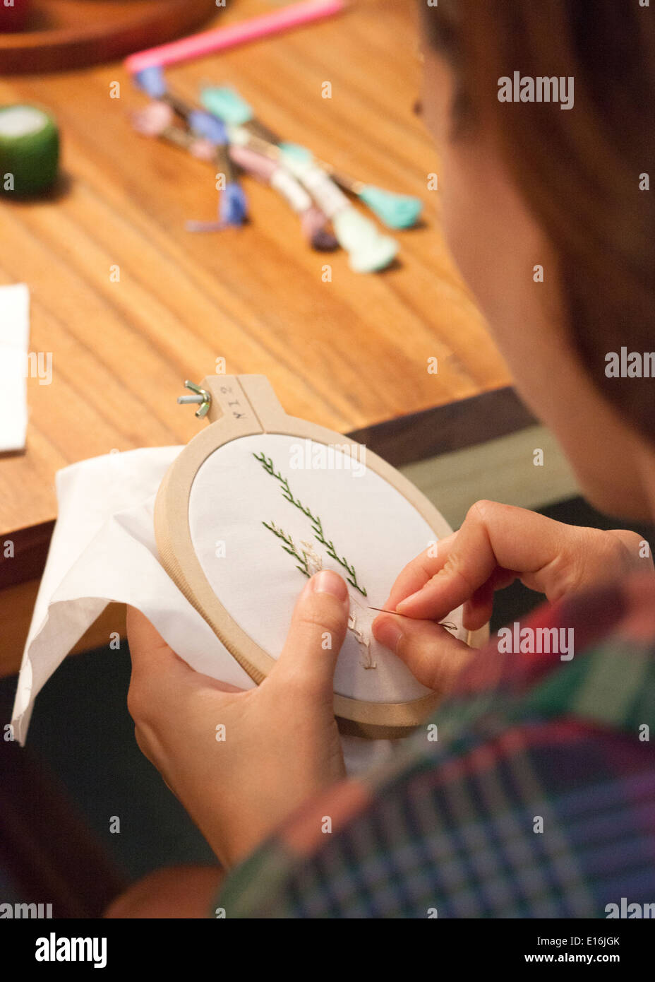 Woman cross stitching Stock Photo - Alamy