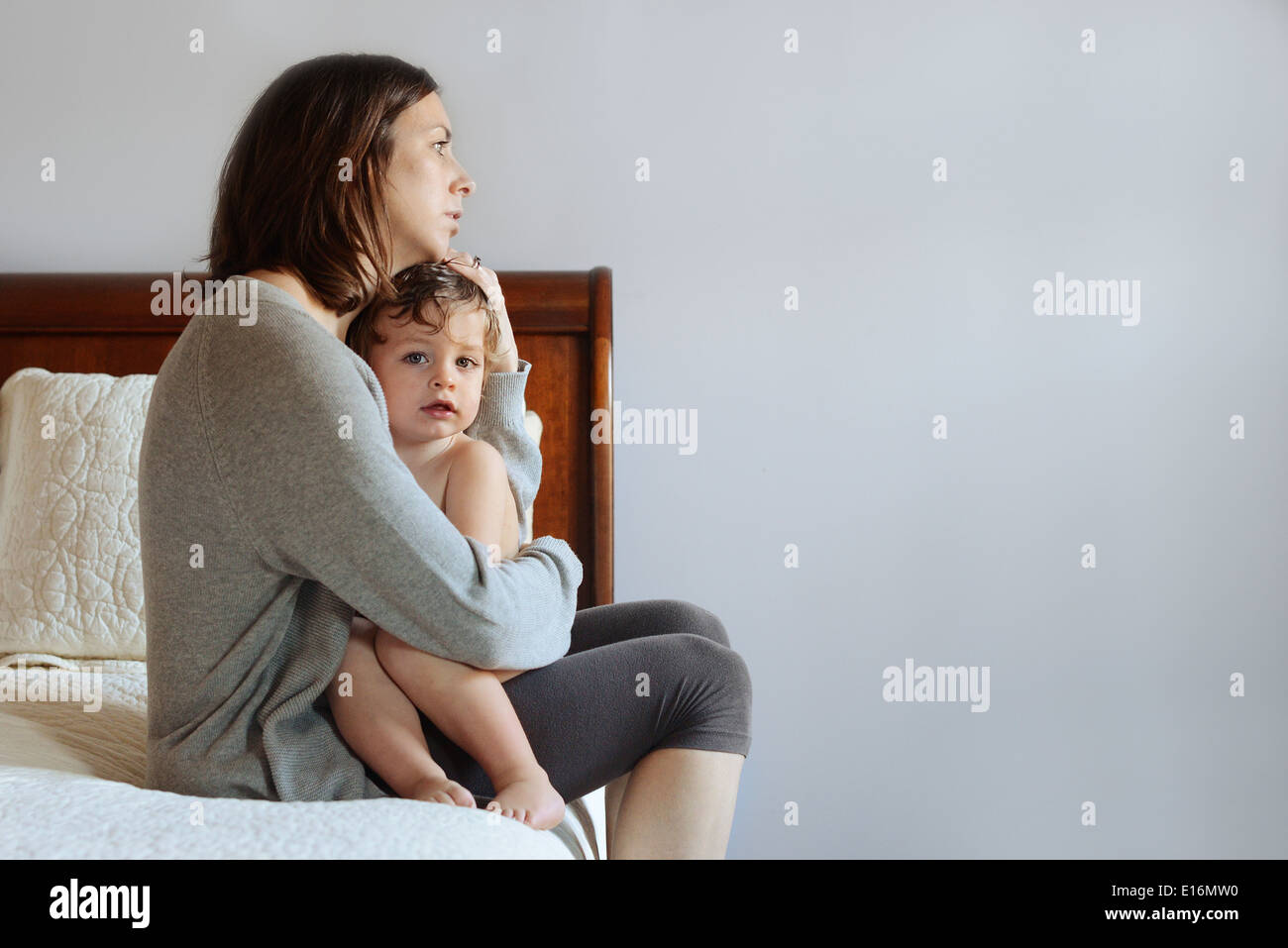 Woman sitting on bed hugging hi-res stock photography and images - Alamy