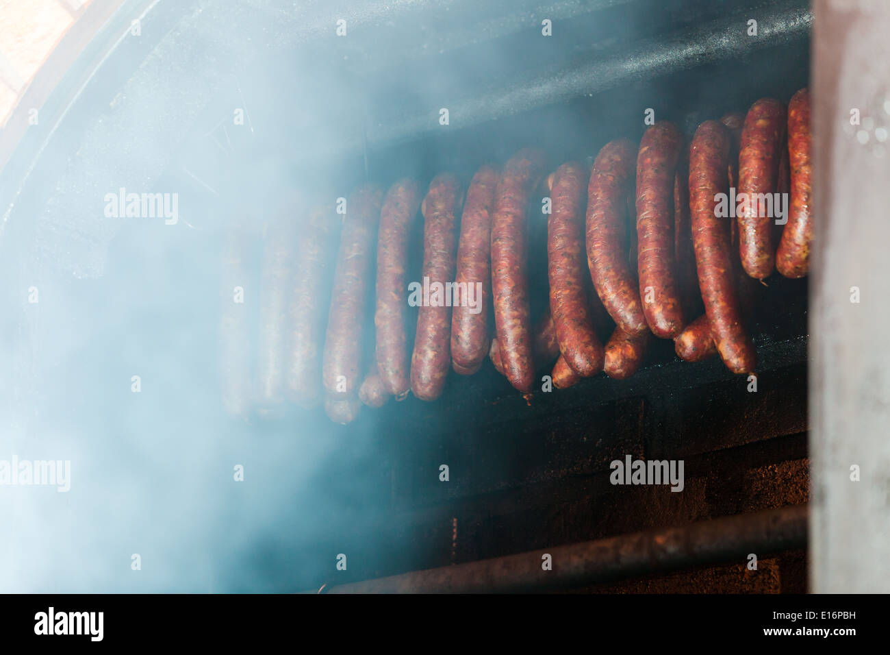 Traditional food. Smoked sausages meat hanging in domestic smokehouse ...