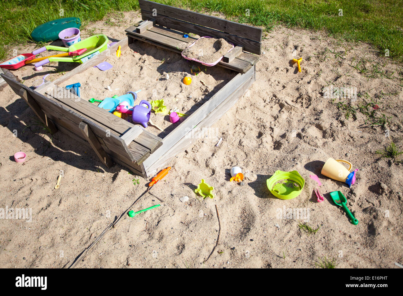 Childhood. Old sandpit sandbox with colorful plastic toys on the ...