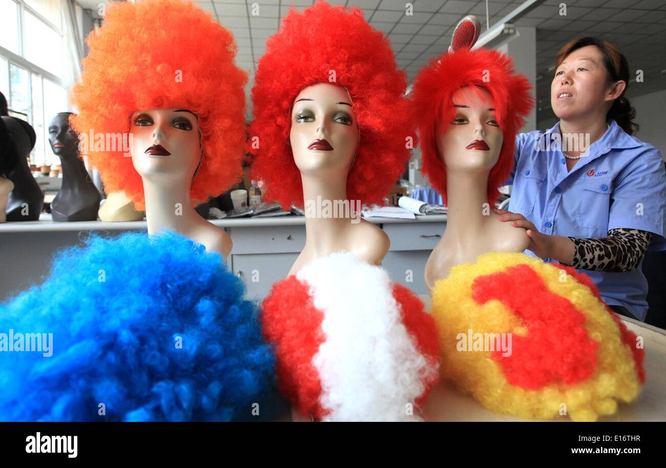 Jimo, China's Shandong Province. 24th May, 2014. A worker combs a wig ...