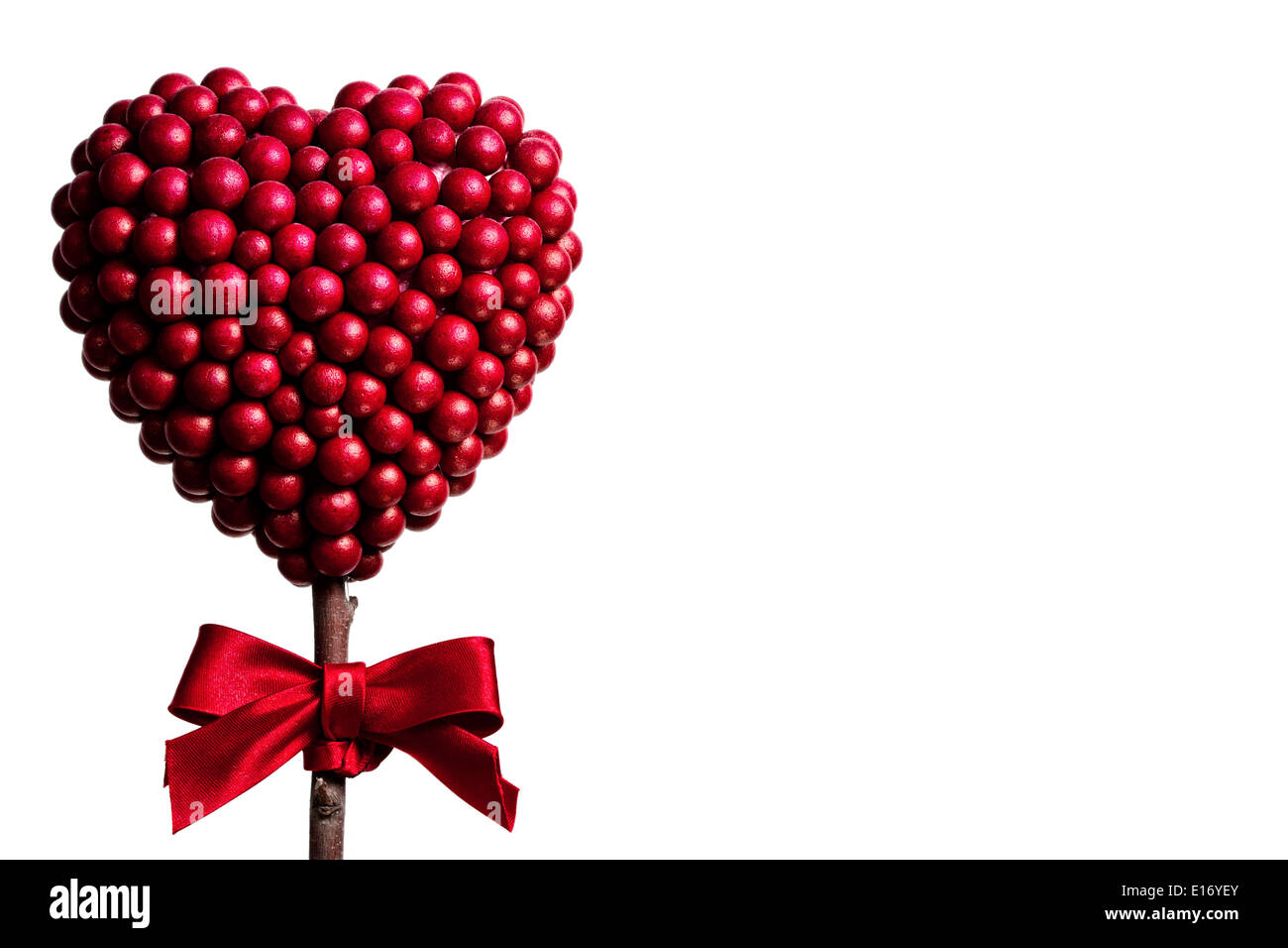 Red heart made of small balls on stick with ribbon isolated on white ...