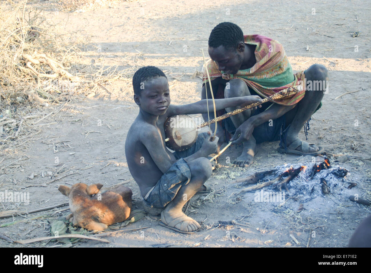Africa, Tanzania, Lake Eyasi, A Hadza child playing a rebab a single ...