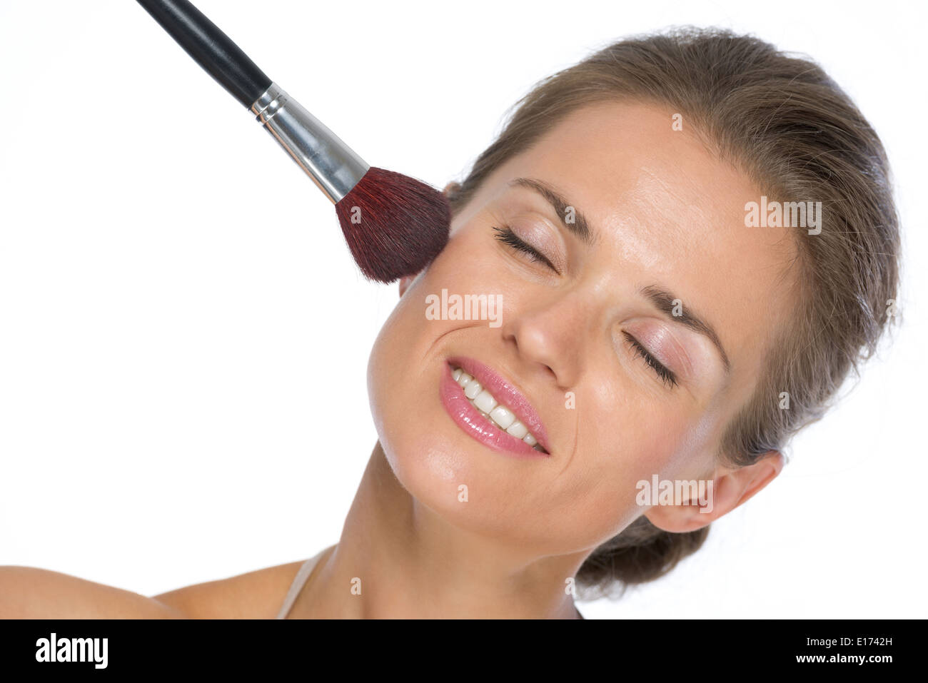 Young woman using makeup brush Stock Photo - Alamy