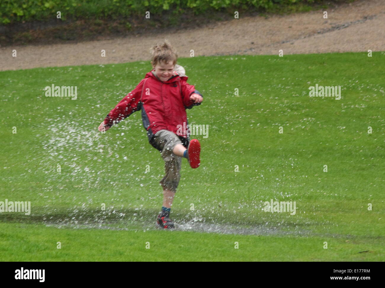 A boy kicks up a puddle on a rainy day at Chatsworth House, Peak ...