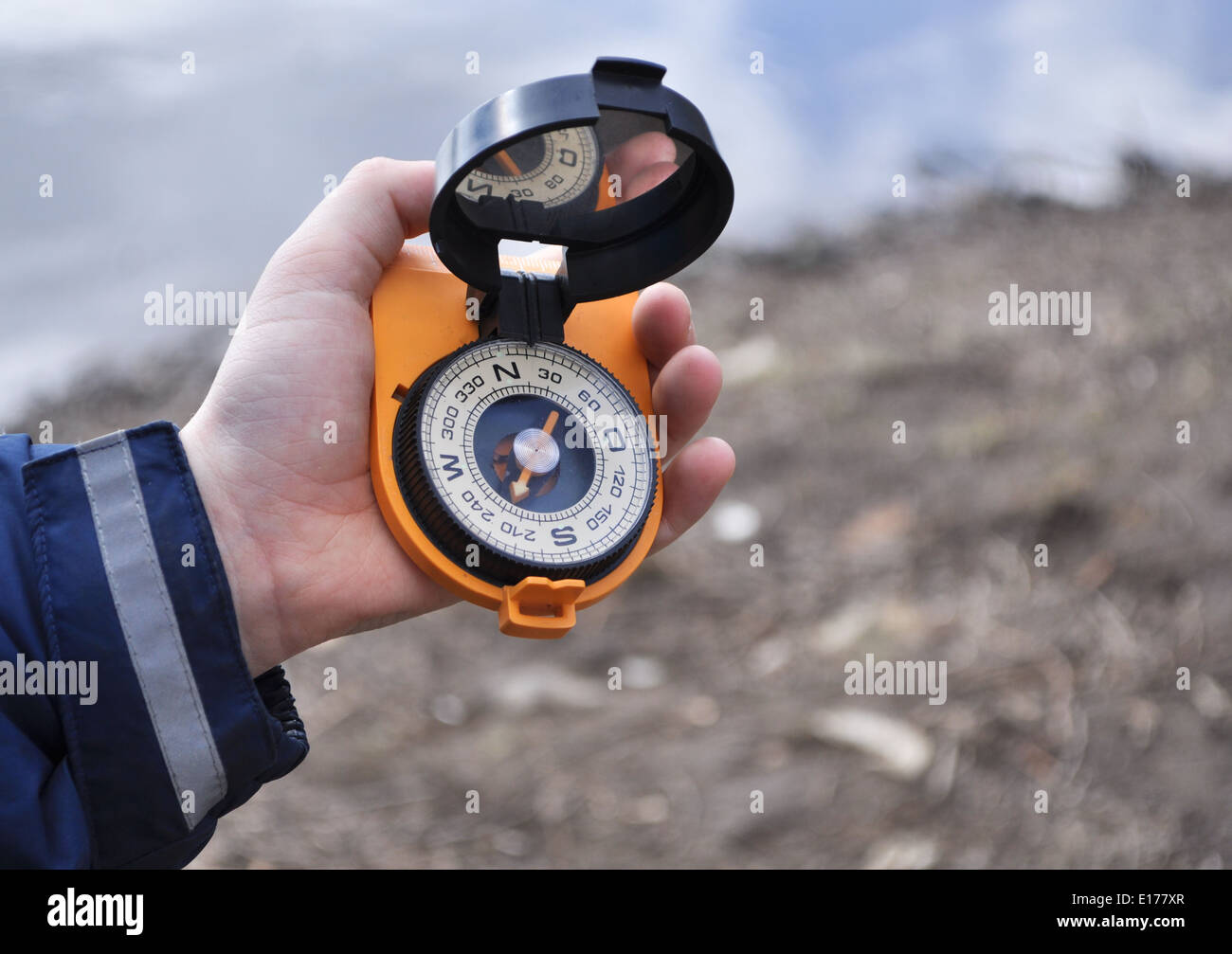 Man holds in his hand the magnetic compass, not to get lost away from ...