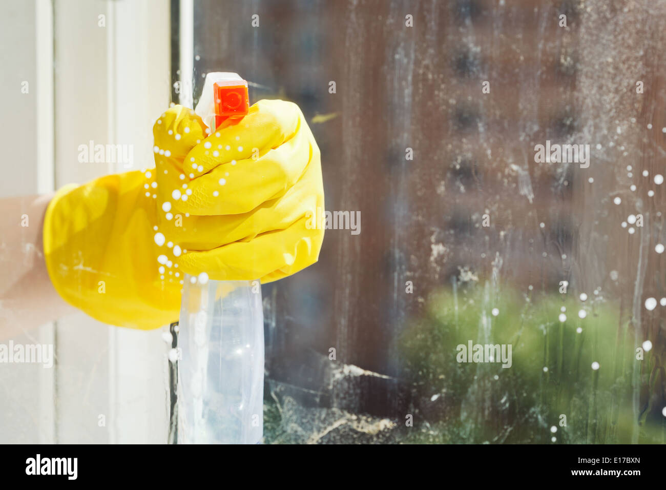 cleaning window from spray glass cleaner bottle Stock Photo - Alamy