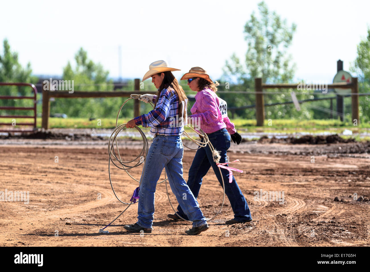 Two cowgirls practice their roping skills outside the rodeo arena prior ...