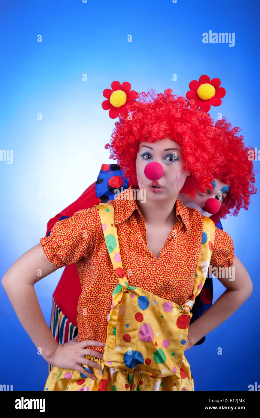 Clown couple in costumes on blue background. Studio professional ...