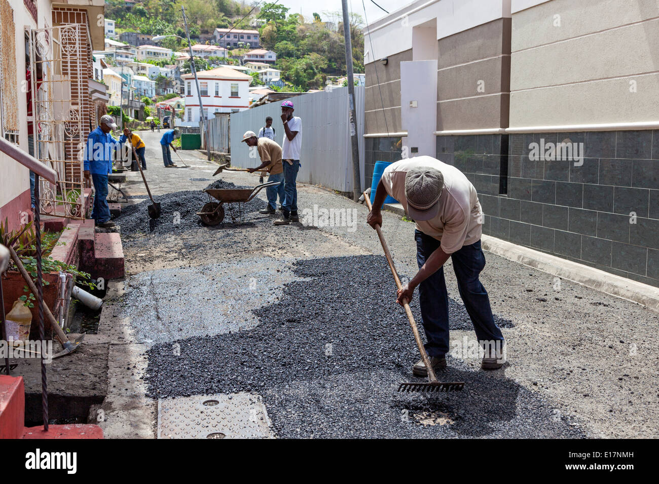 Workmen repairing a road, using tar and handheld tools, in St George ...
