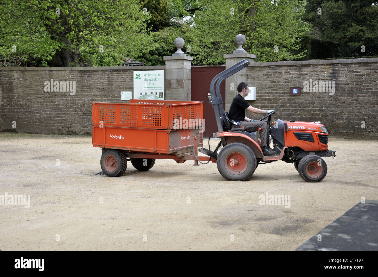 Kubota B series tractor with operator driver and attached trailer Stock ...