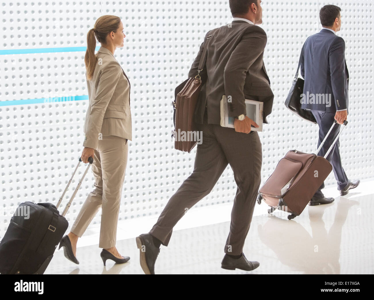 Business people pulling suitcases in corridor Stock Photo - Alamy